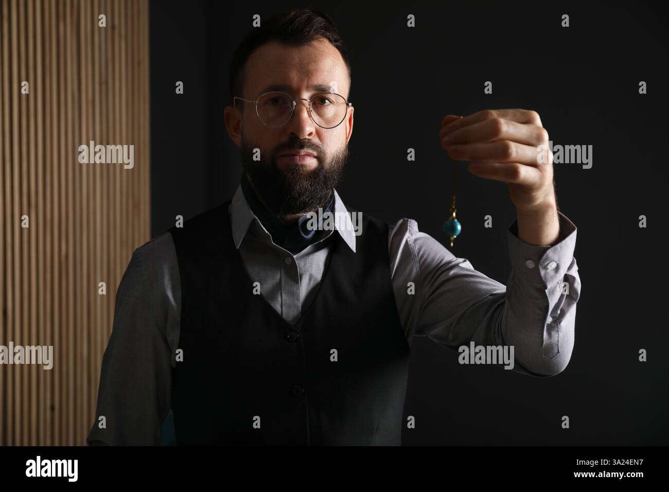 Hypnosis session. Man in glasses swinging pendulum indoors Stock Photo ...