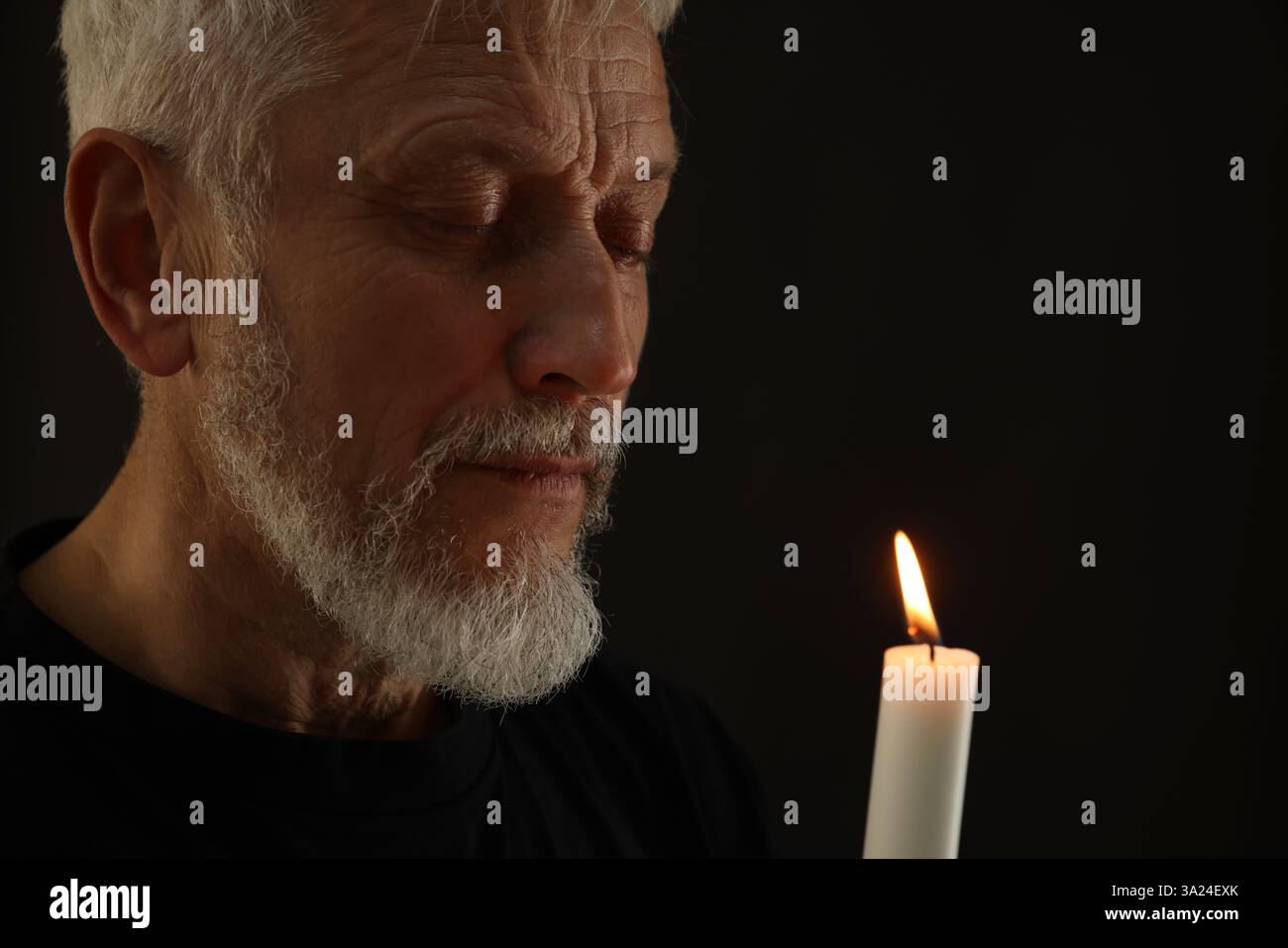 Sad senior man with burning candle crying on black background. Grieving ...