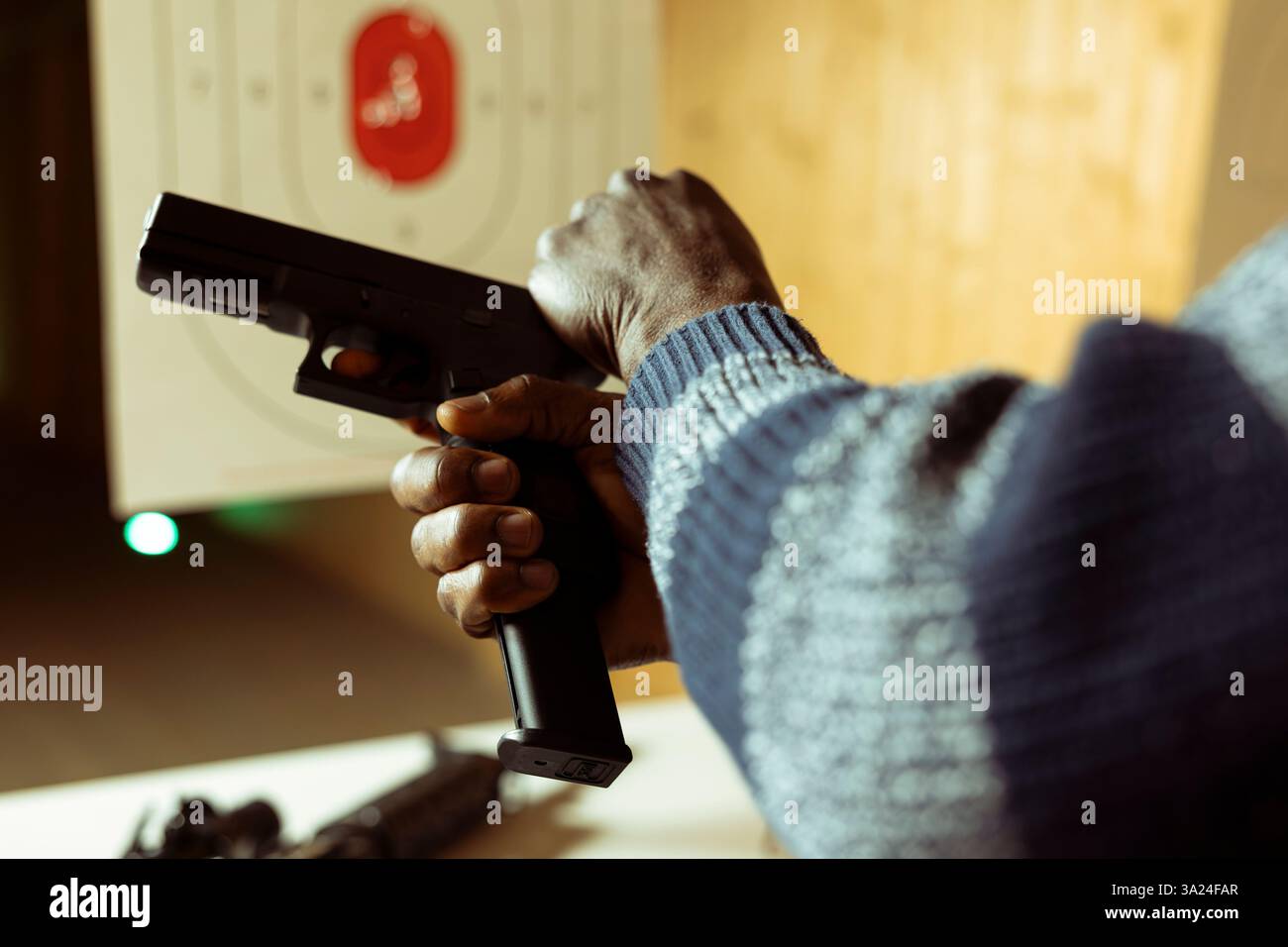 Gun hobbyist specialist in shooting range cocking handgun, setting ...