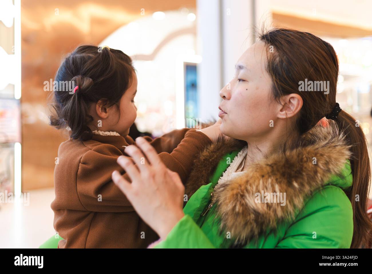 Chinese mother and daughter talking while taking a break from shopping ...