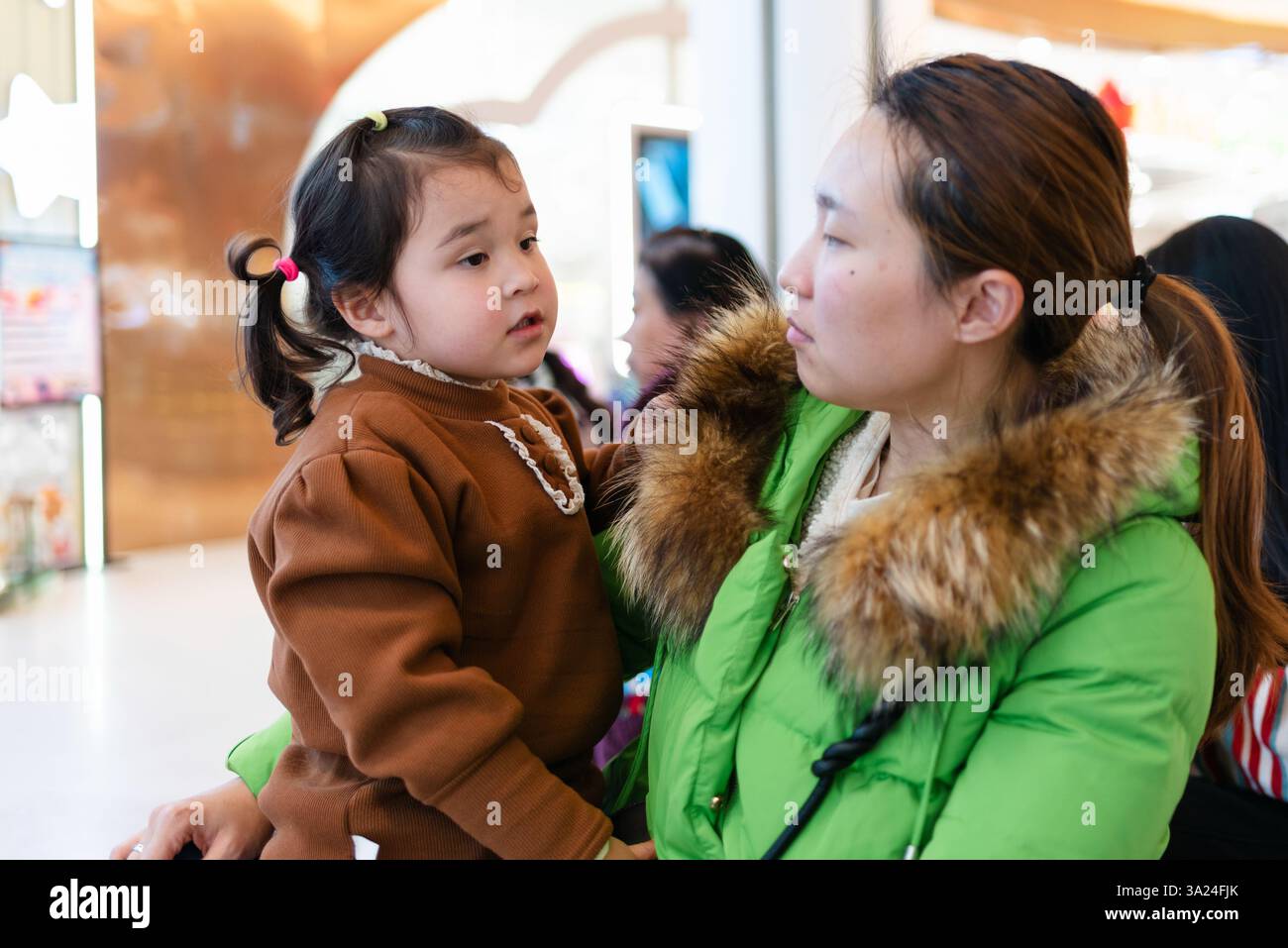 Chinese mother and daughter talking while taking a break from shopping ...