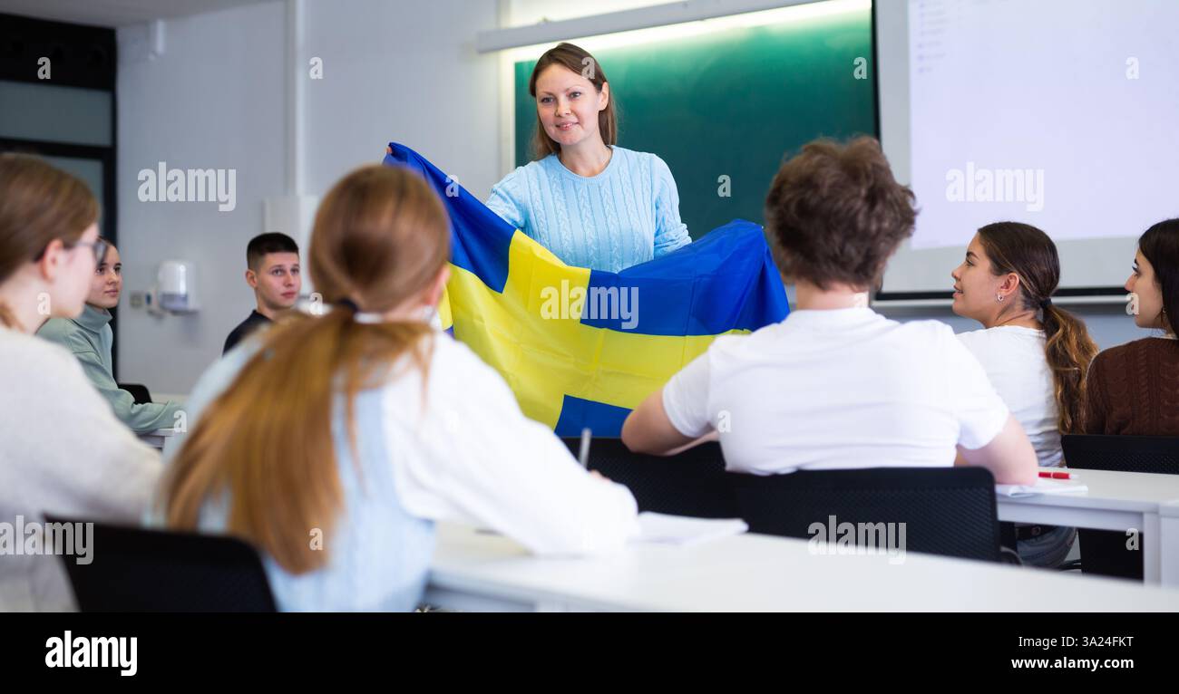 Female professor shows students flag of Sweden Stock Photo - Alamy