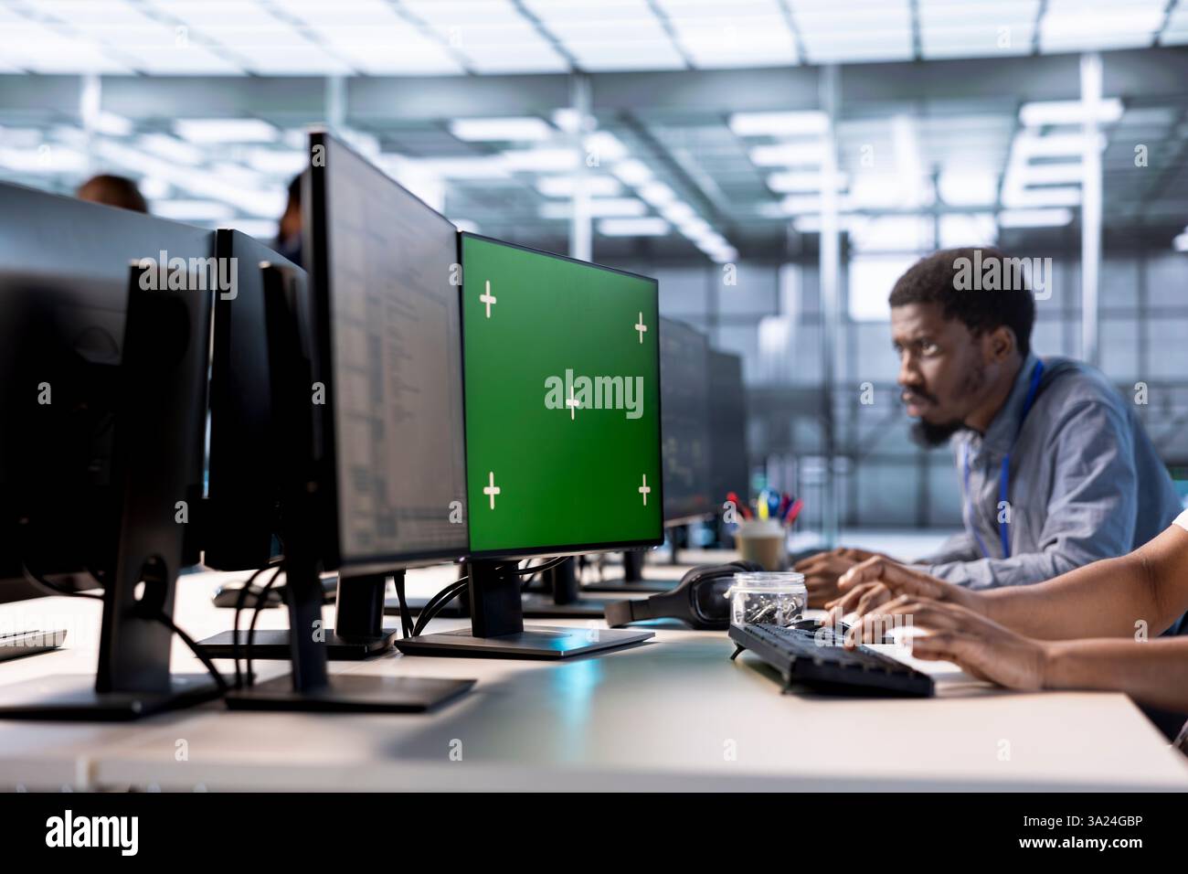 Engineer in server hub ensuring data remains shielded from potential threats using green screen ...