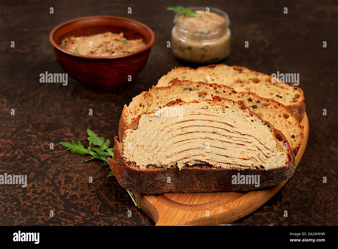 Homemade whole grain bread with chicken pate and arugula on a concrete ...