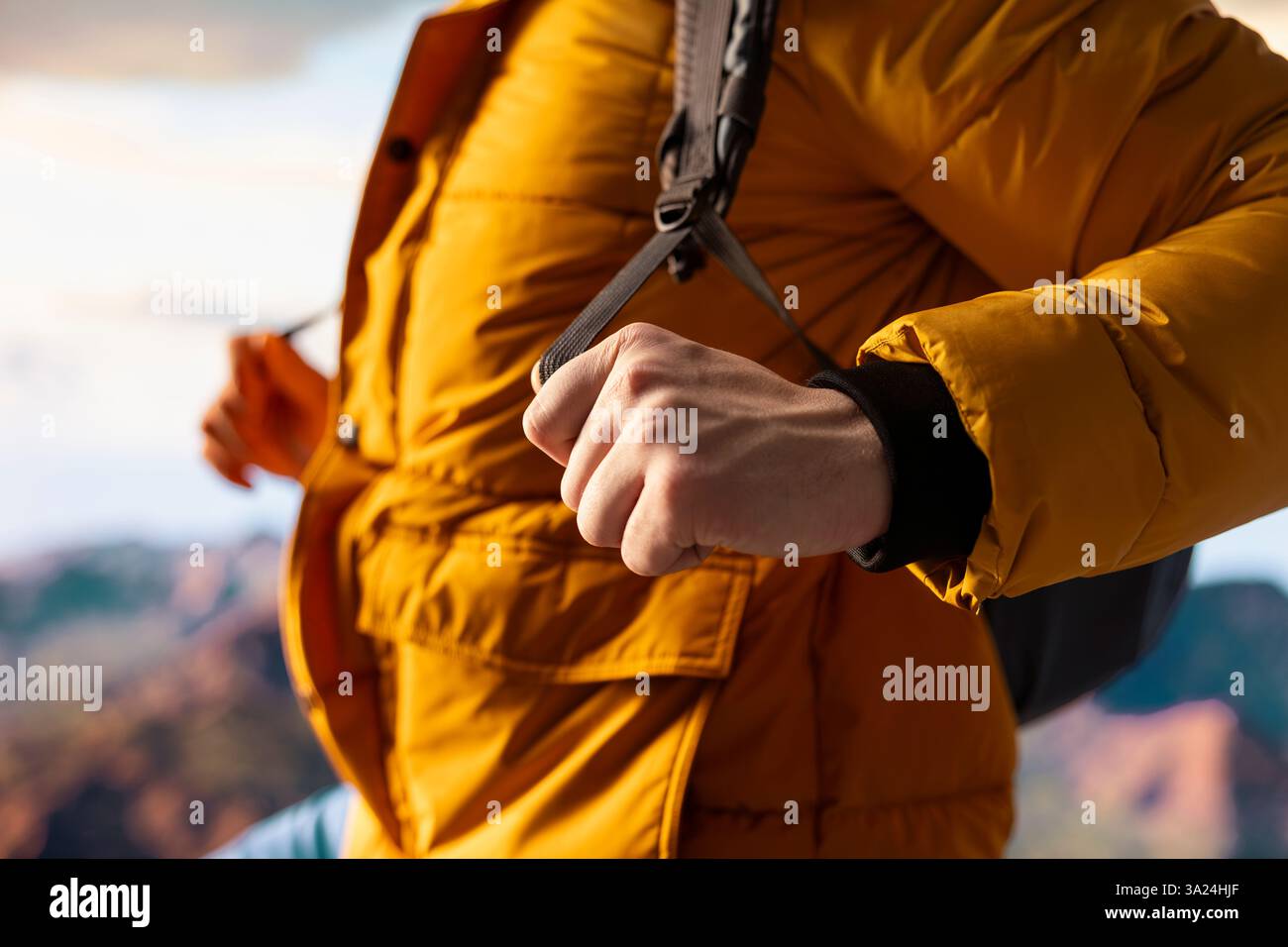 Determined traveler enjoys the solitude of a mountain summit, where the ...