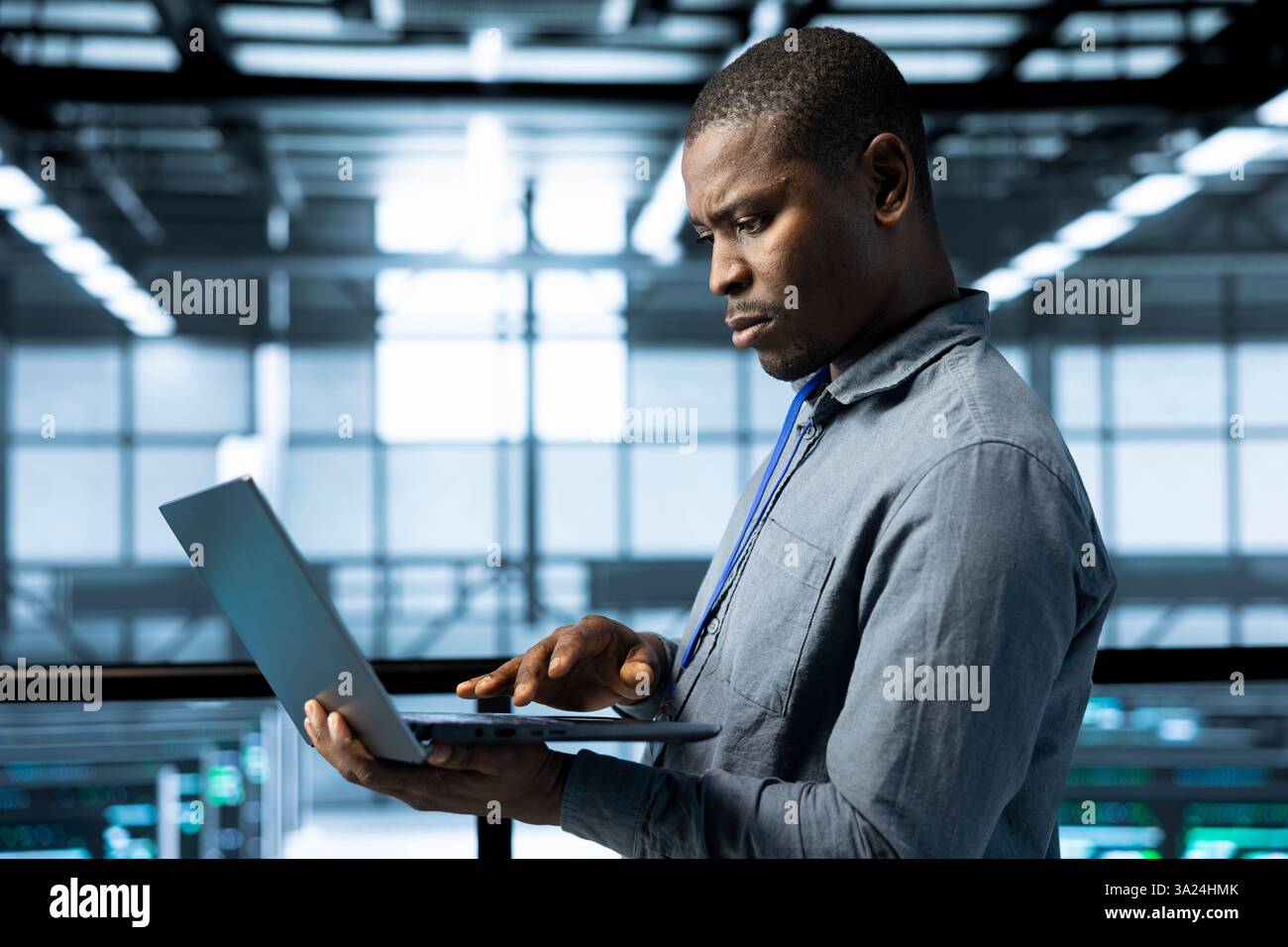 African american engineer in data center with laptop automating routine ... African american engineer in data center with laptop automating routine ...