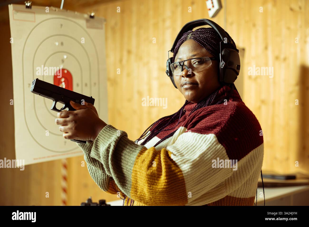 Portrait of shooting range client trying out new handgun model before ...