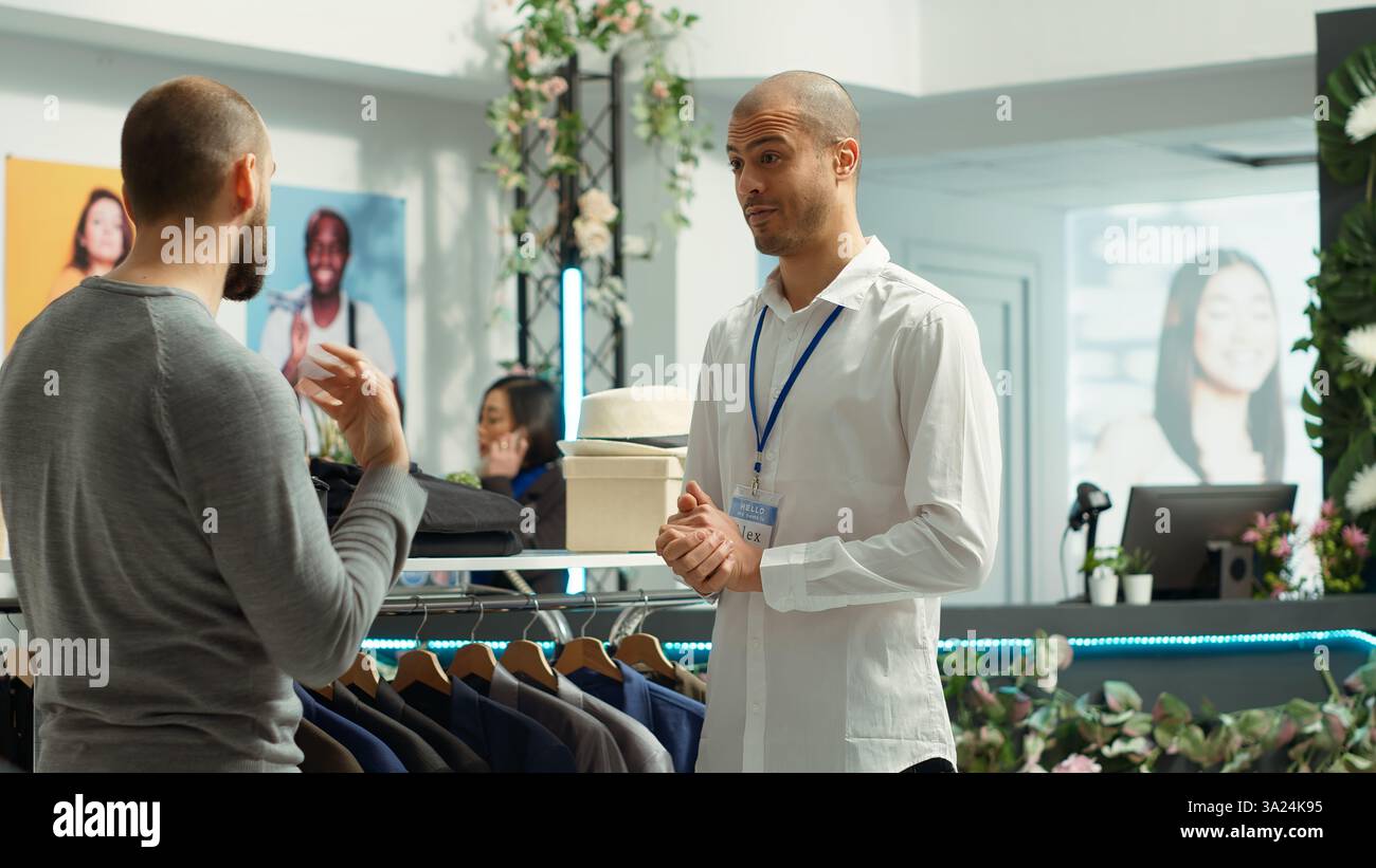 Retail store worker assisting a young man client with style advice ...