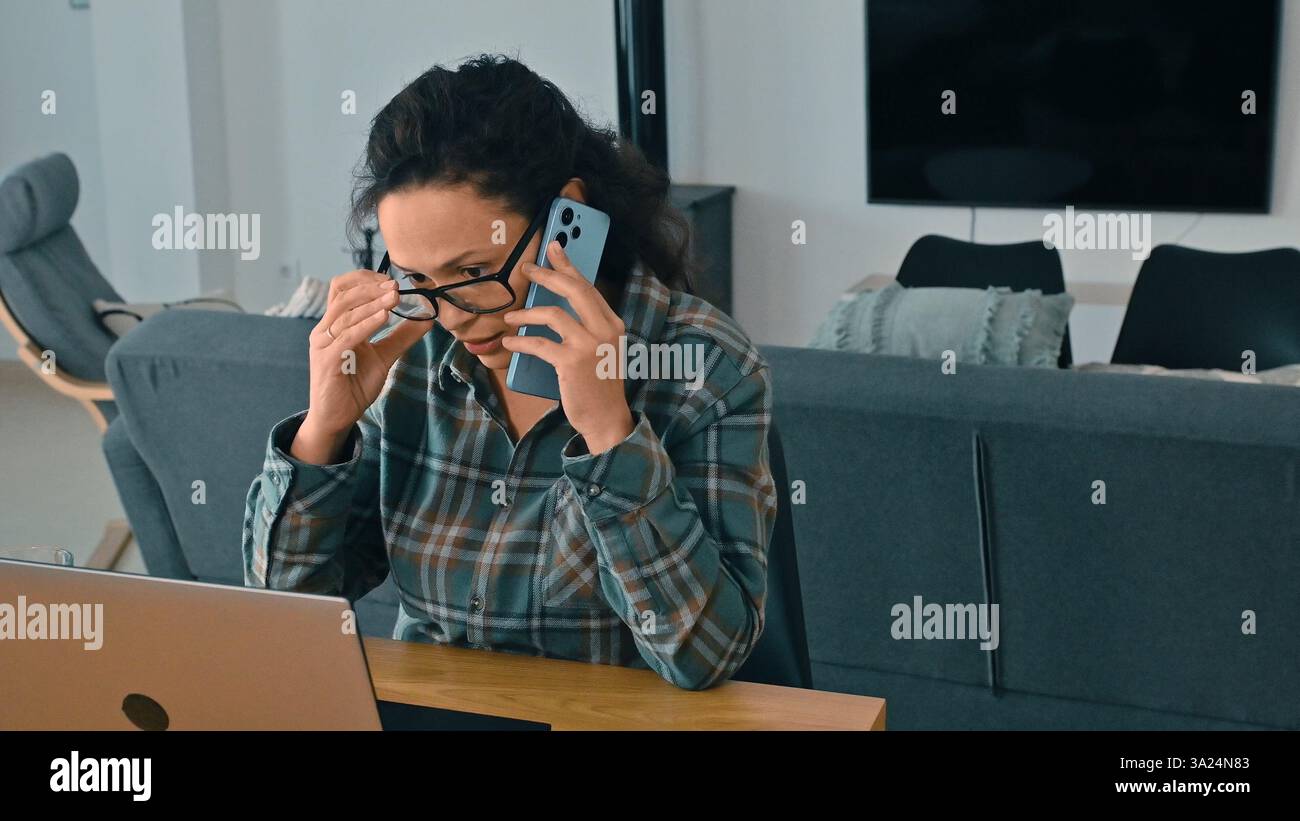 Female professional handling tasks from home, balancing phone call and ...