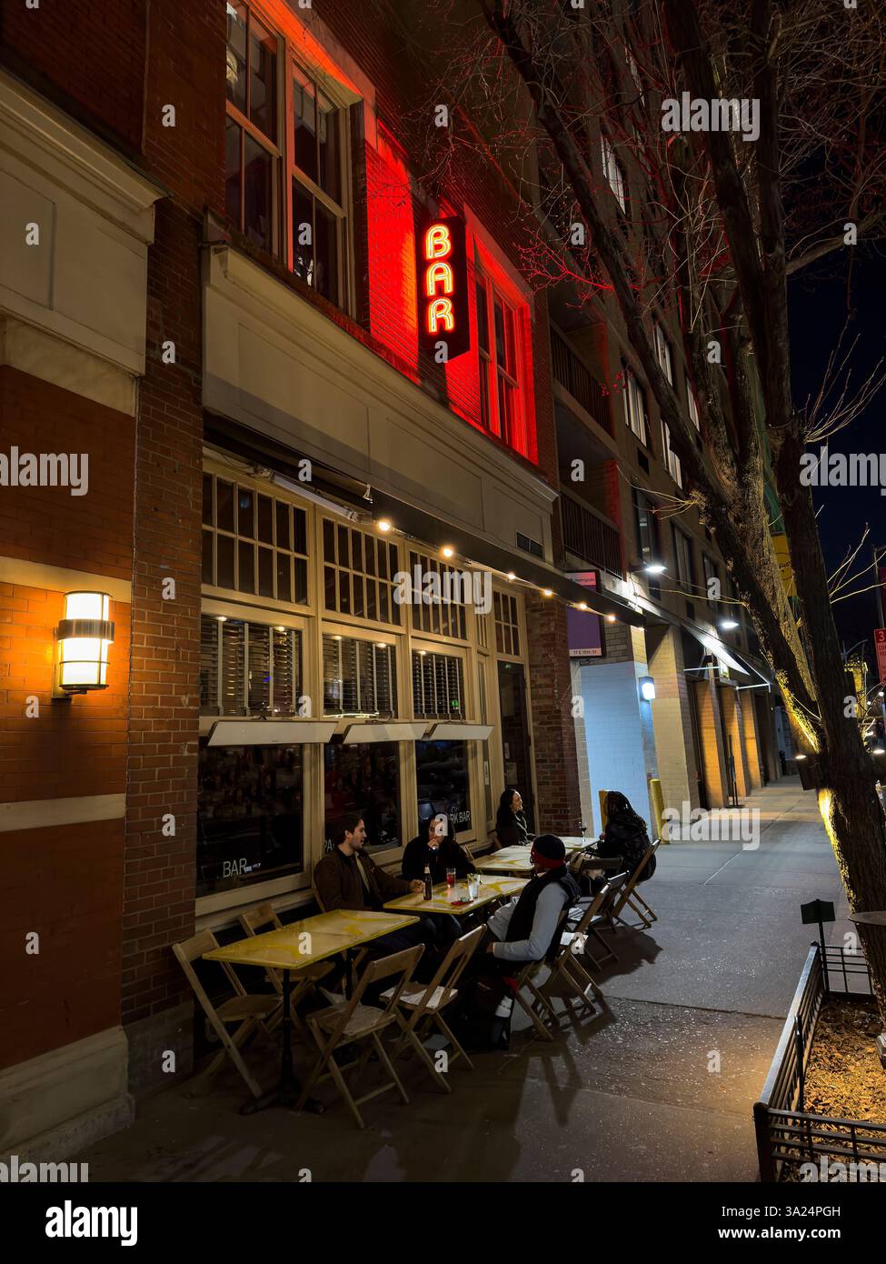 Group of people sitting at sidewalk bar at night, New York City, New ...