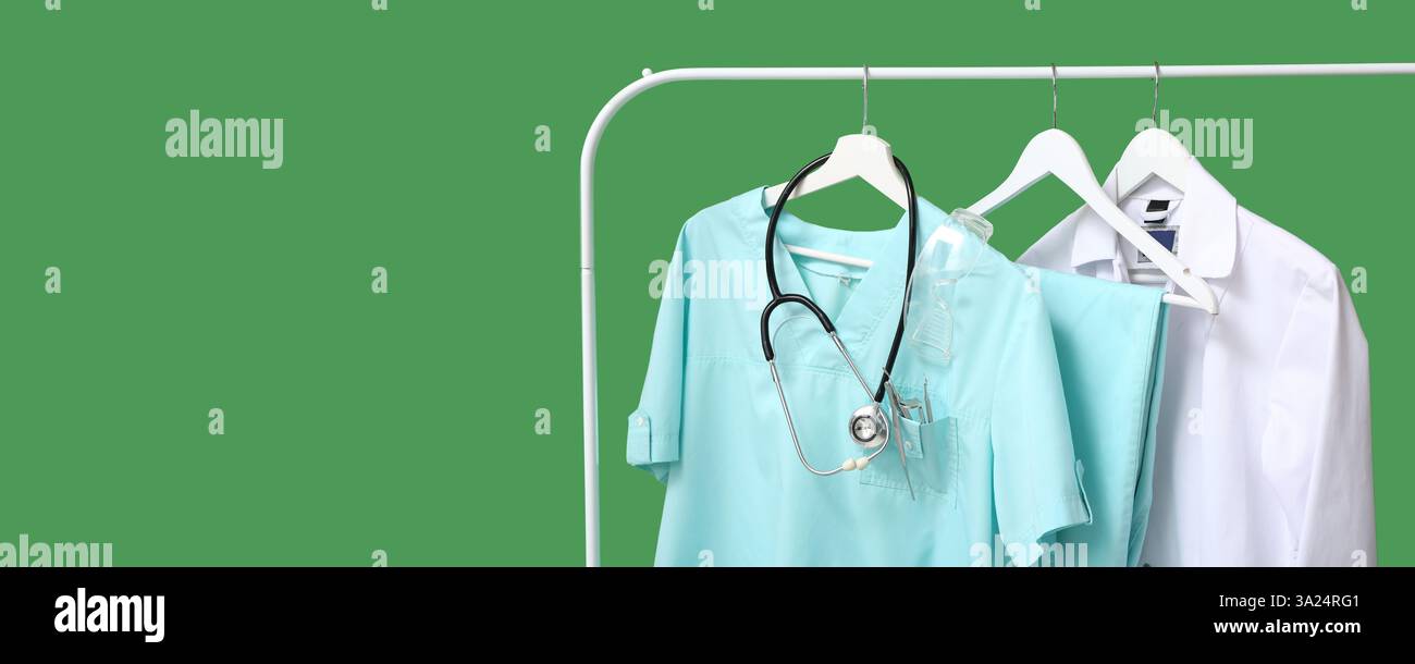 Medical uniform hanging on rack with stethoscope and dental tools on ...