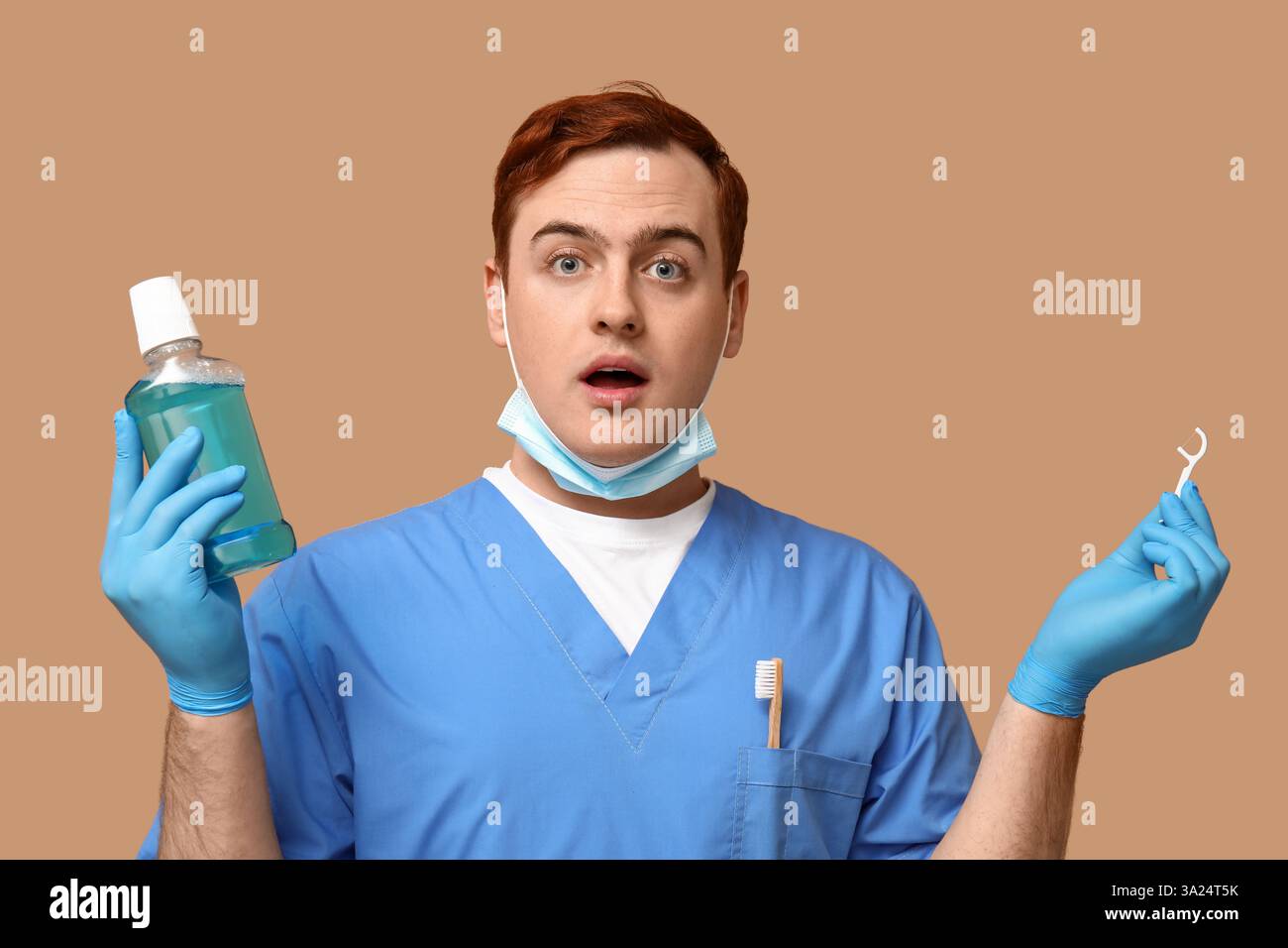 Male dentist with bottle of mouth rinse and floss toothpick on beige ...