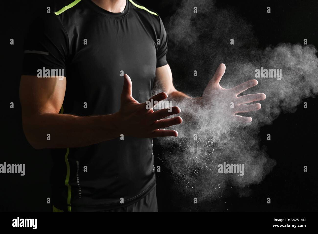 Man clapping hands with talcum powder before training on black ...