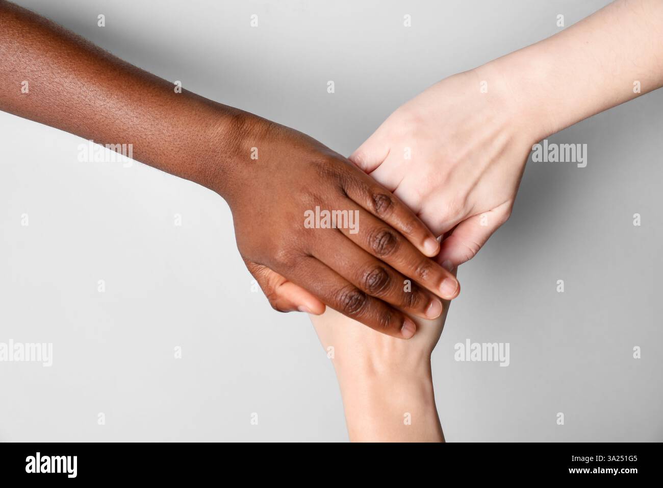Stop racism. People of different skin colors joining hands on light ...