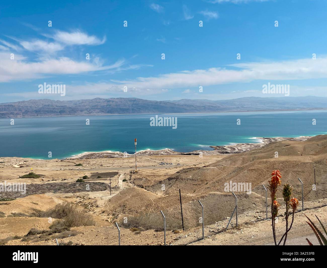A panoramic view of the Dead Sea, surrounded by a rugged desert ...