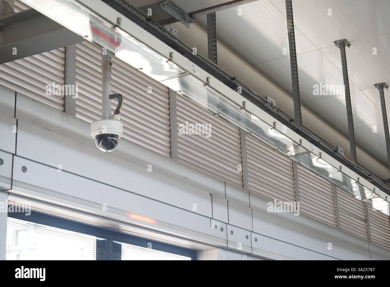 Security camera mounted on industrial ceiling in a modern building ...