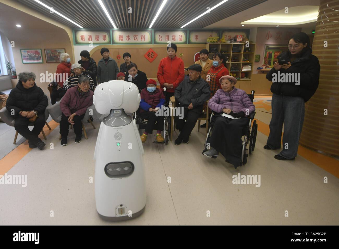 HANGZHOU, CHINA - MARCH 12, 2025 - Elderly people chat with Xiao Xi, an ...