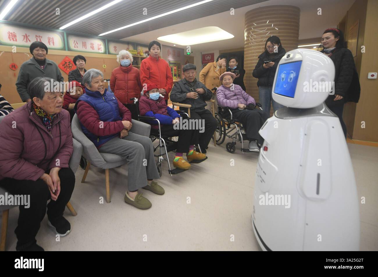 HANGZHOU, CHINA - MARCH 12, 2025 - Elderly people chat with Xiao Xi, an ...