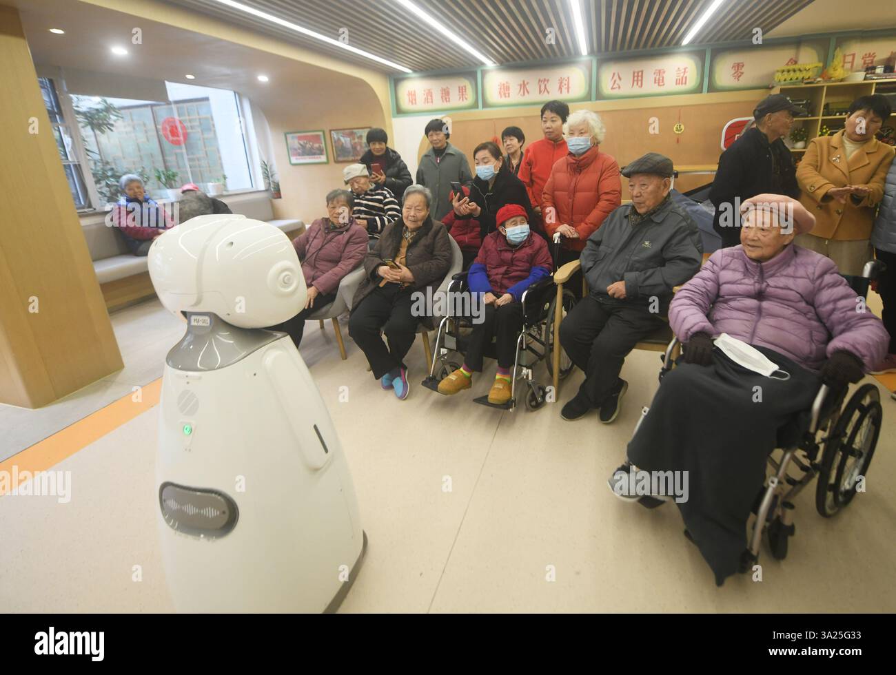 HANGZHOU, CHINA - MARCH 12, 2025 - Elderly people chat with Xiao Xi, an ...