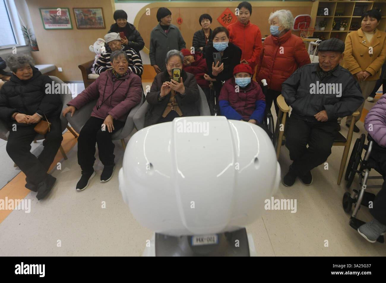 HANGZHOU, CHINA - MARCH 12, 2025 - Elderly people chat with Xiao Xi, an ...