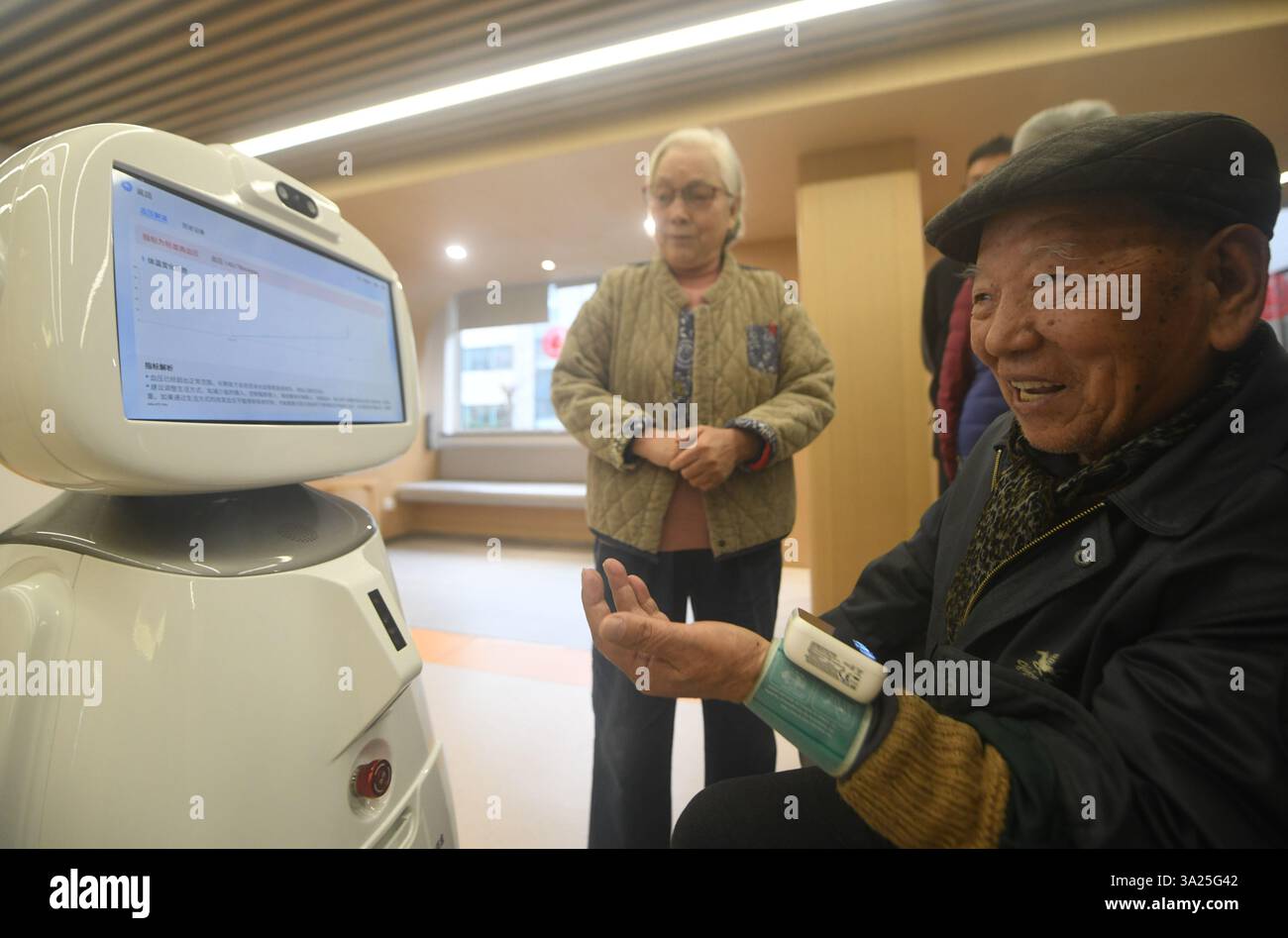 HANGZHOU, CHINA - MARCH 12, 2025 - Elderly people chat with Xiao Xi, an ...