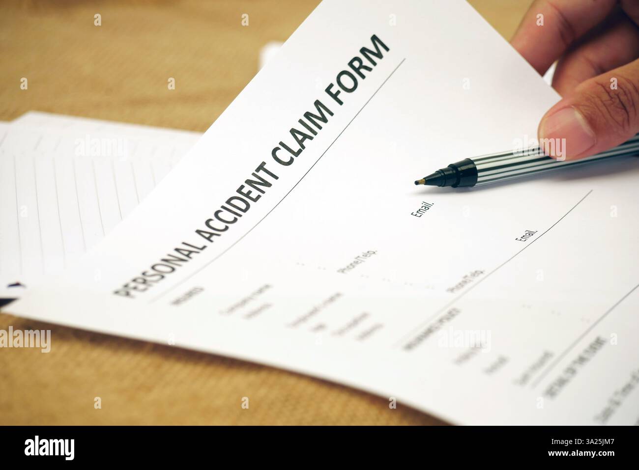 Hand holding pen filling out personal accident claim form details Stock ...
