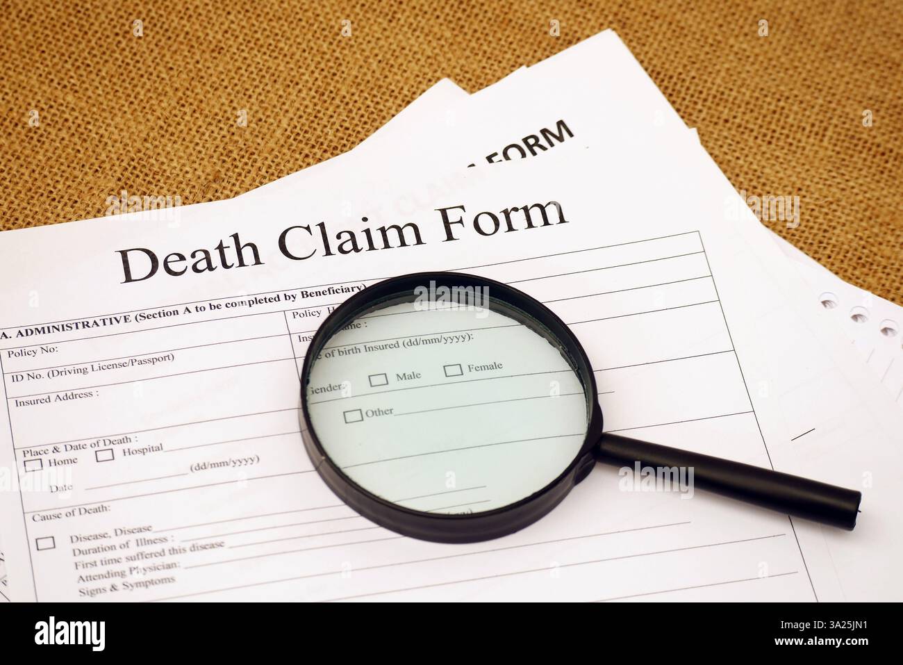 Death claim form with magnifying glass, symbolizing verification and ...