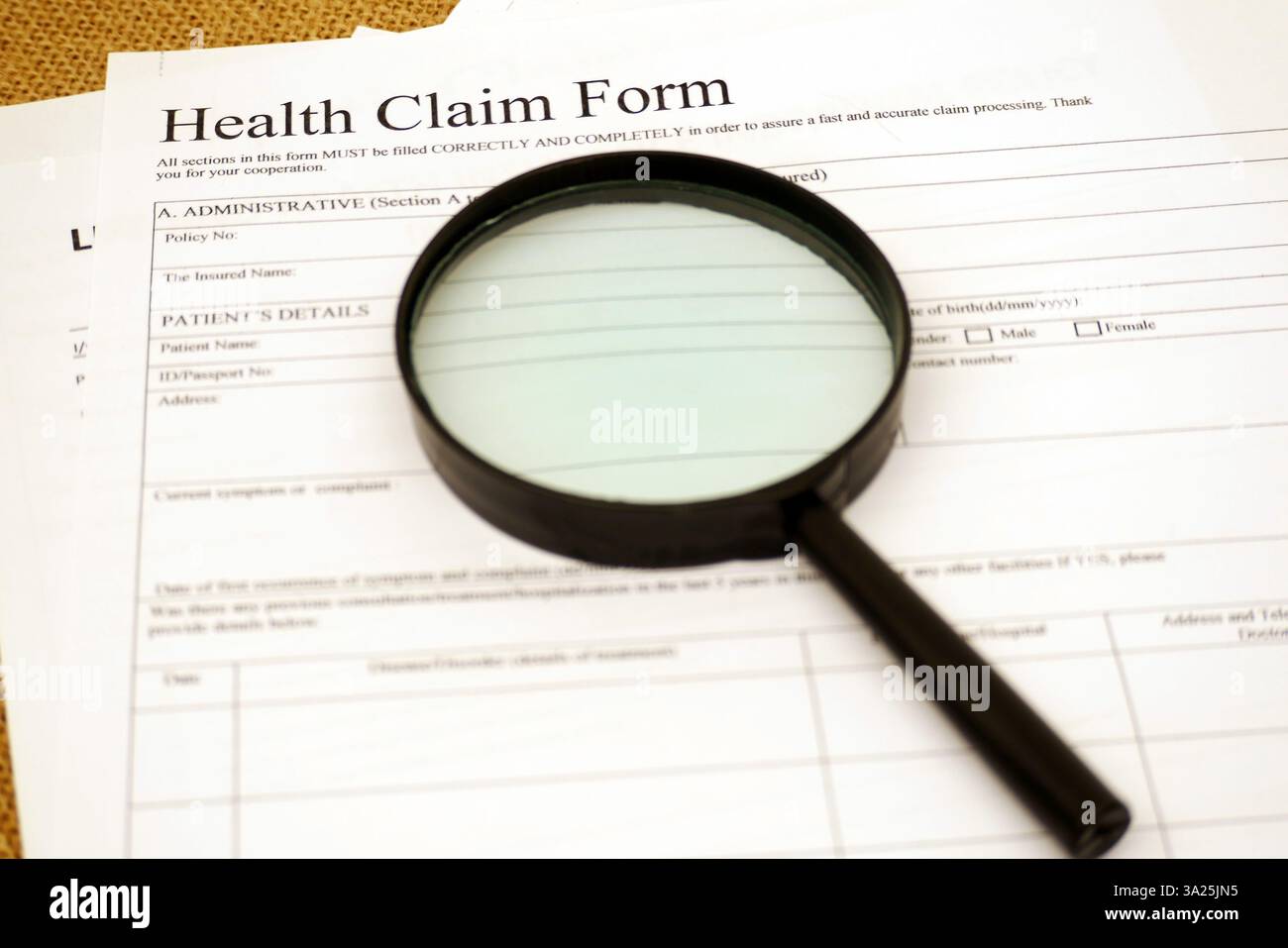 A health claim form with a magnifying glass symbolizing careful ...