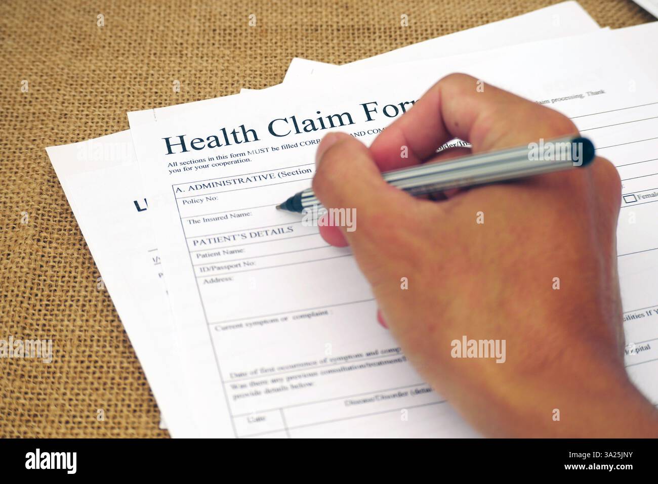 Hands filling out health claim form Stock Photo - Alamy