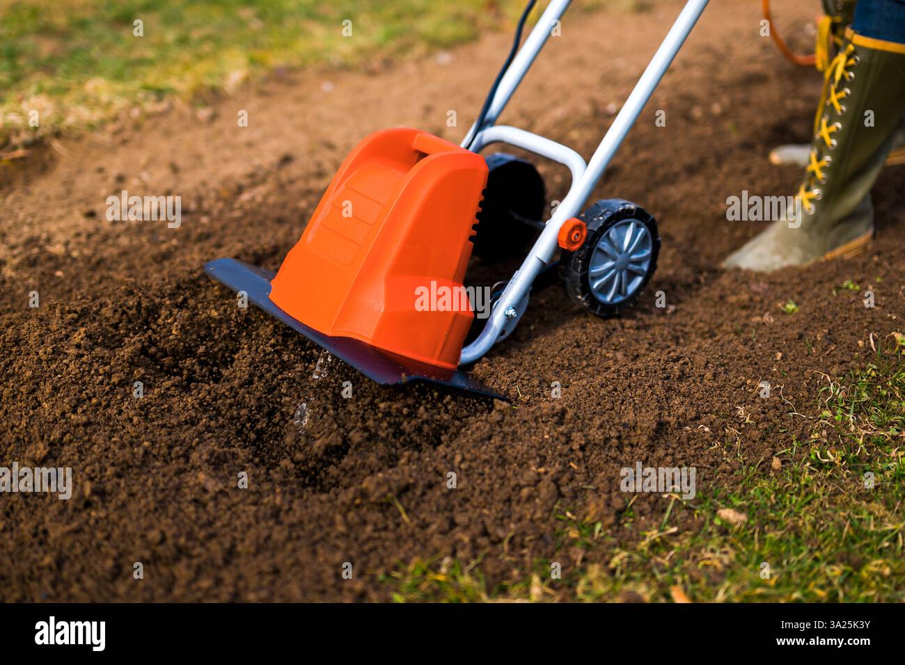 Woman preparing garden beds for planting. Rotavator, garden tiller ...