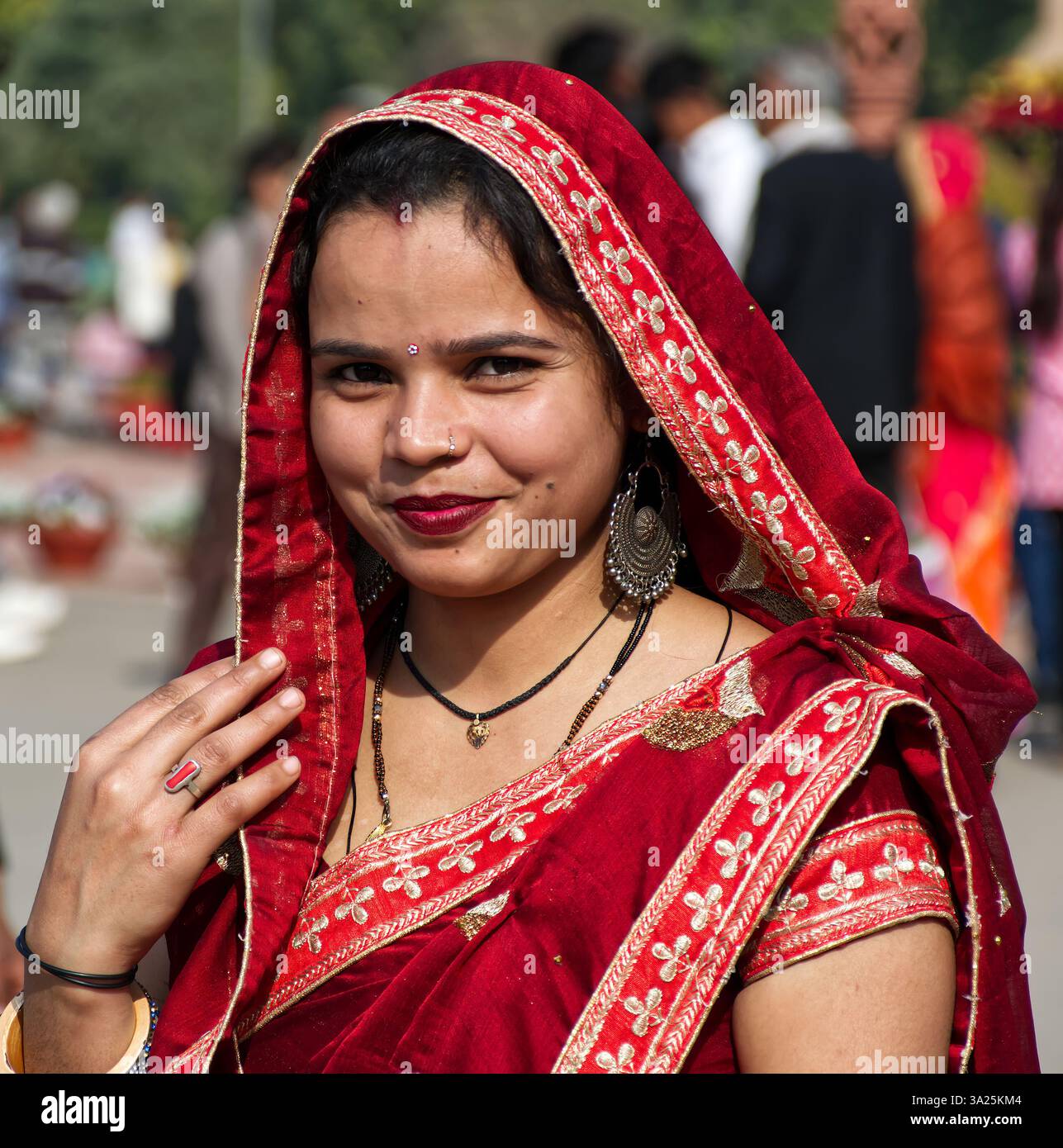 Smiling Indian woman in traditional vibrant red sari and headscarf ...