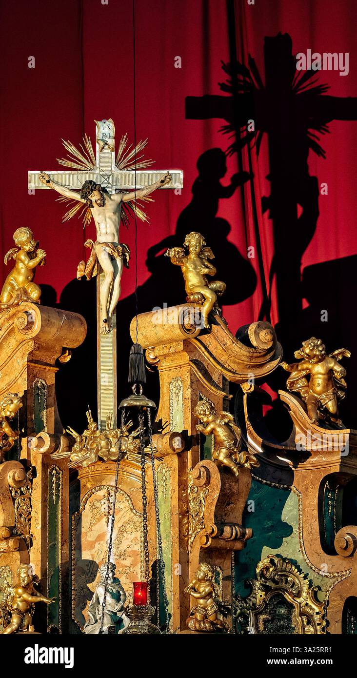 Golden Religious Altar with Crucifix and Dramatic Shadow on Red Curtain ...