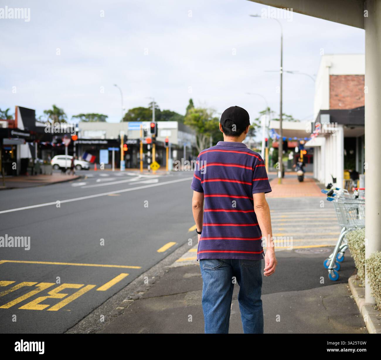 Man walking on the pedestrian walkway. BUS sign painted on the roadside ...