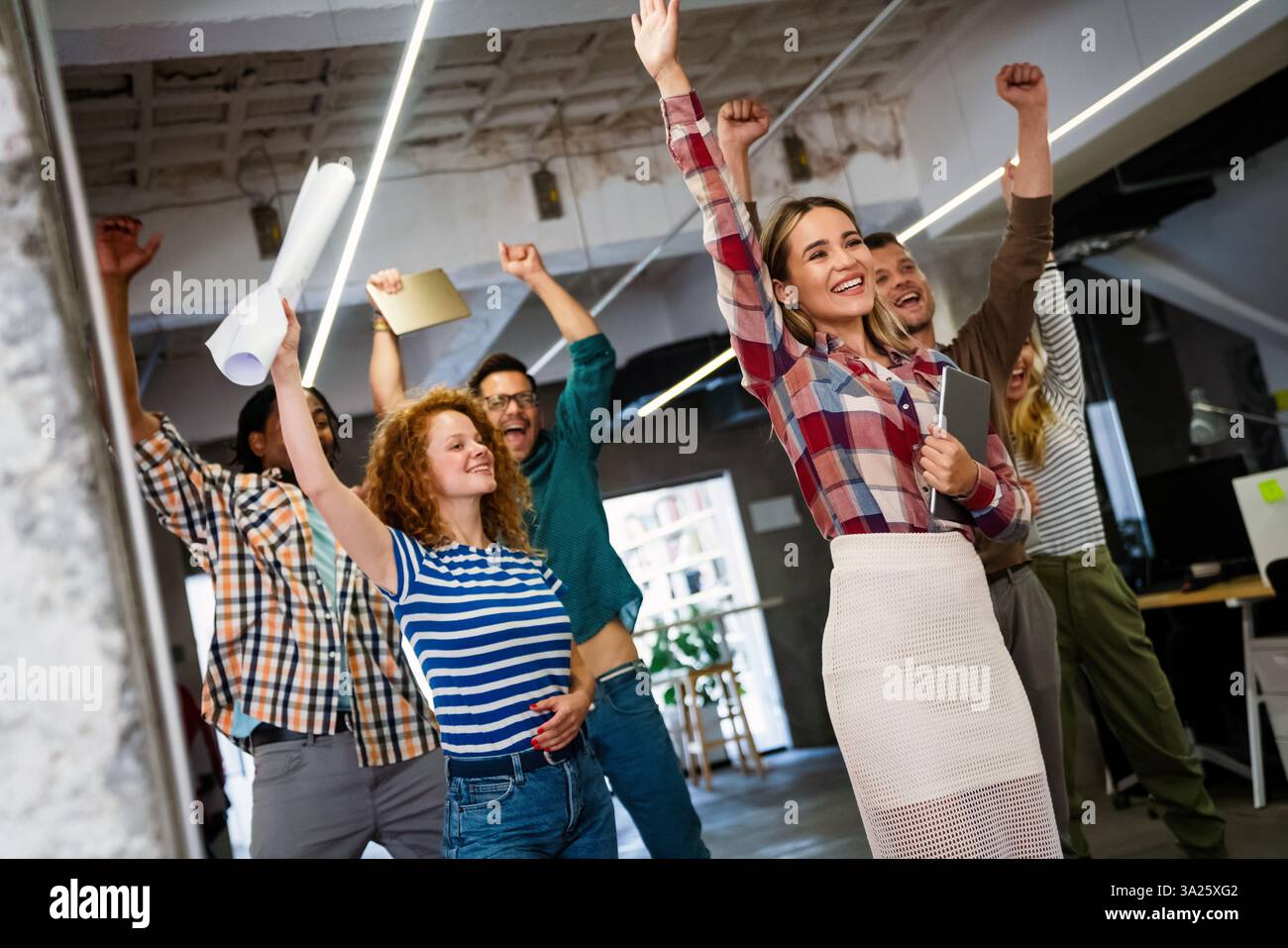 Happy business people celebrating success at company Stock Photo - Alamy