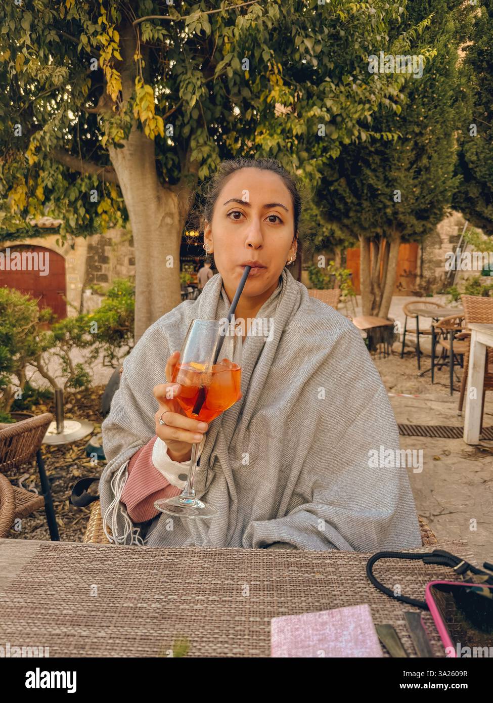 Latin woman takes a spritz in a Spanish town Stock Photo - Alamy