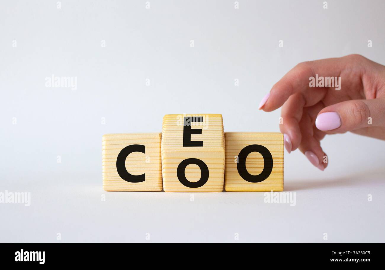 CEO and COO symbol. Businessman hand turns wooden cubes and changes ...