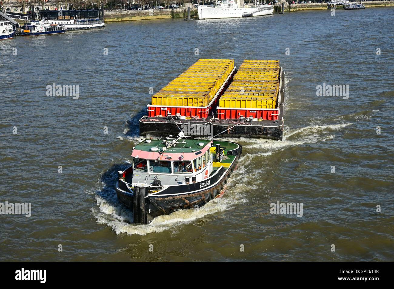 Tug 'Reclaim' hauling barge of containers upstream on the River Thames ...