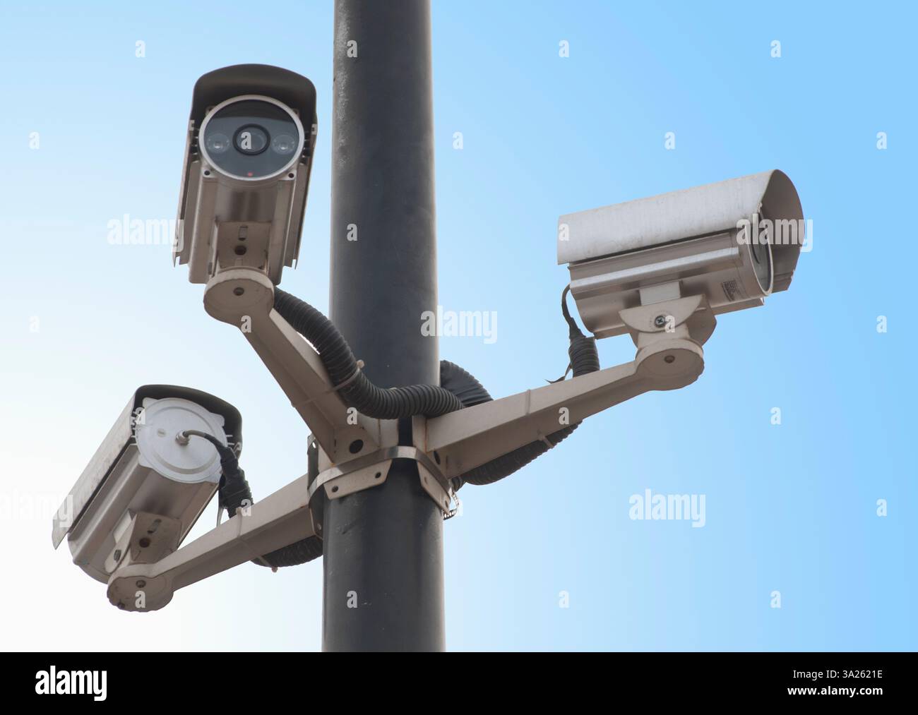 A metal post with a gantry and traffic cameras facing in three ...