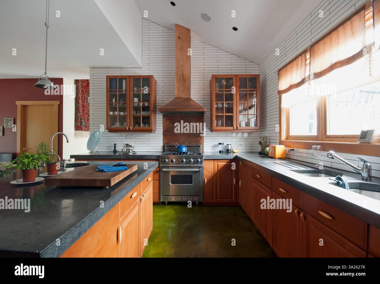 Fitted kitchen units, shelves,and sink by the window. A central island ...