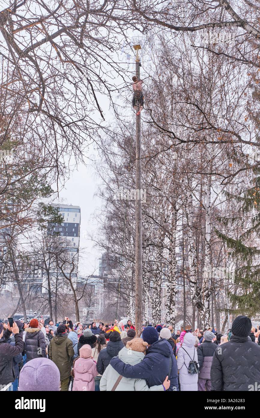 Yekaterinburg, Russia - February 26, 2025: Young man climbs tall ...