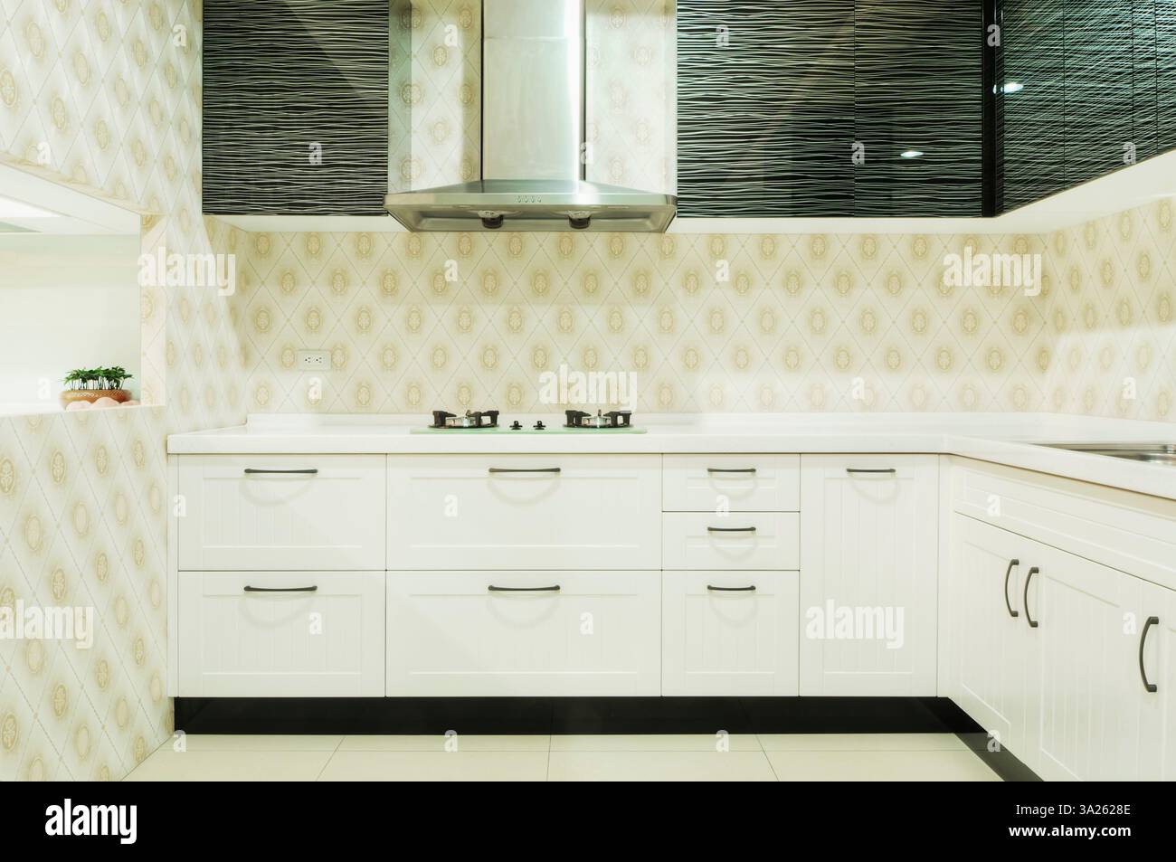 Small modern kitchen with fitted units with white doors. Black glass ...