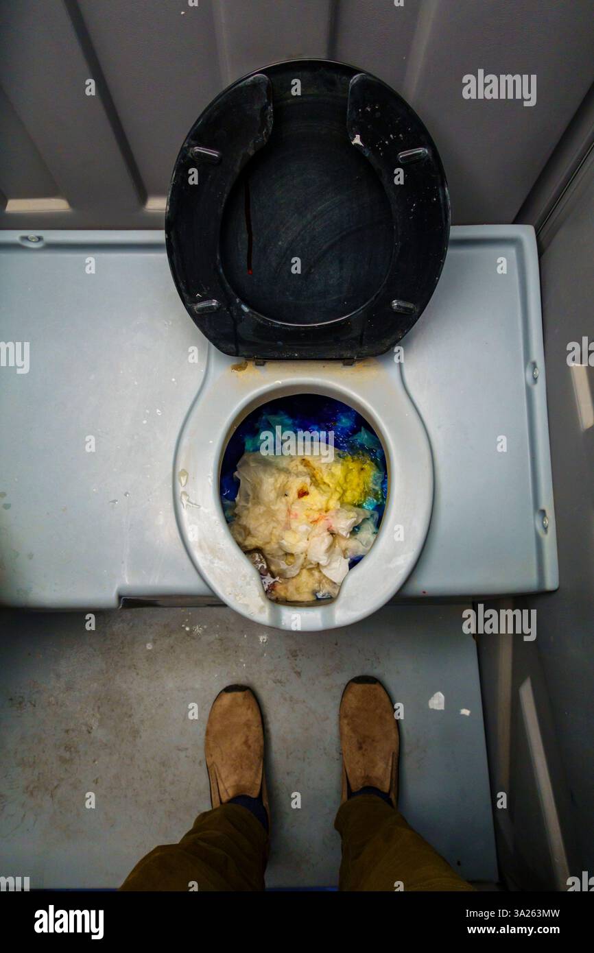 Public reststop toilet, view from above of a dirty blocked bowl full of ...
