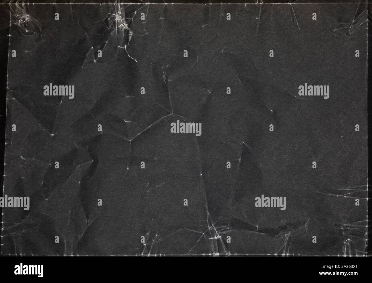 A textured piece of black paper shows visible creases and folds. This ...