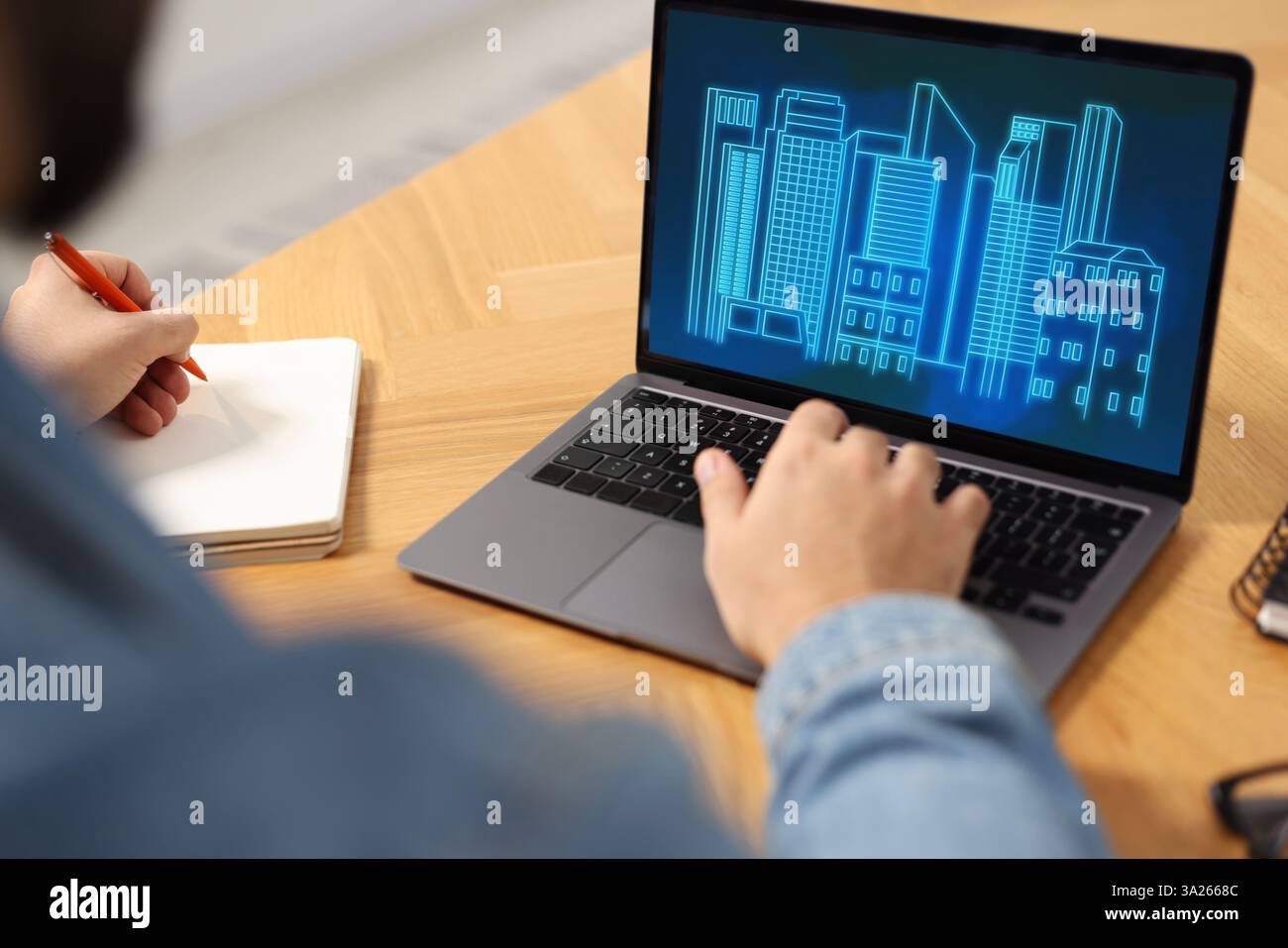 Building information modeling. Man working at laptop indoors, closeup ...