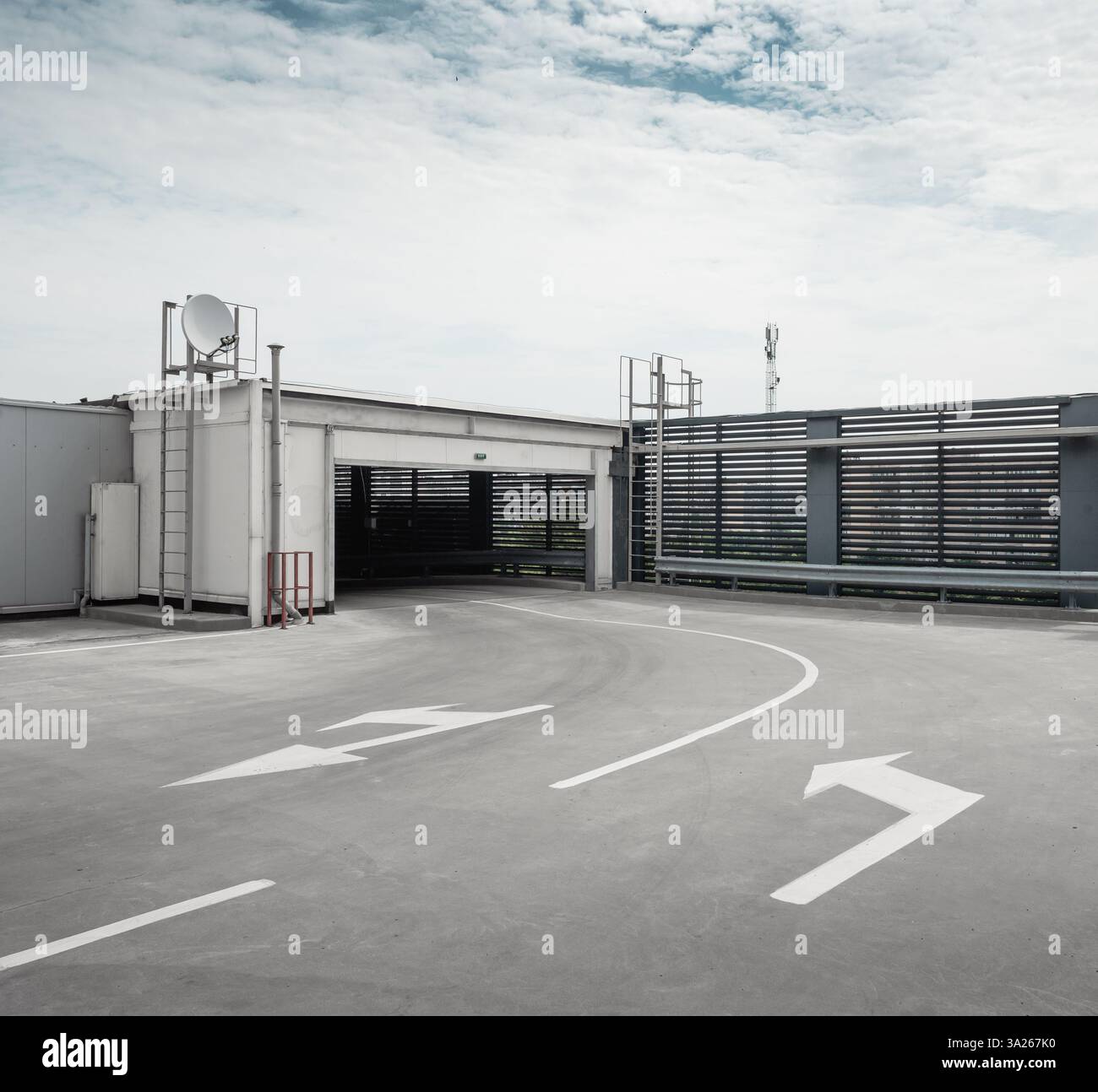 Exit from the upper floor of multi-storey parking garage. Empty turn with arrows on the floor ...