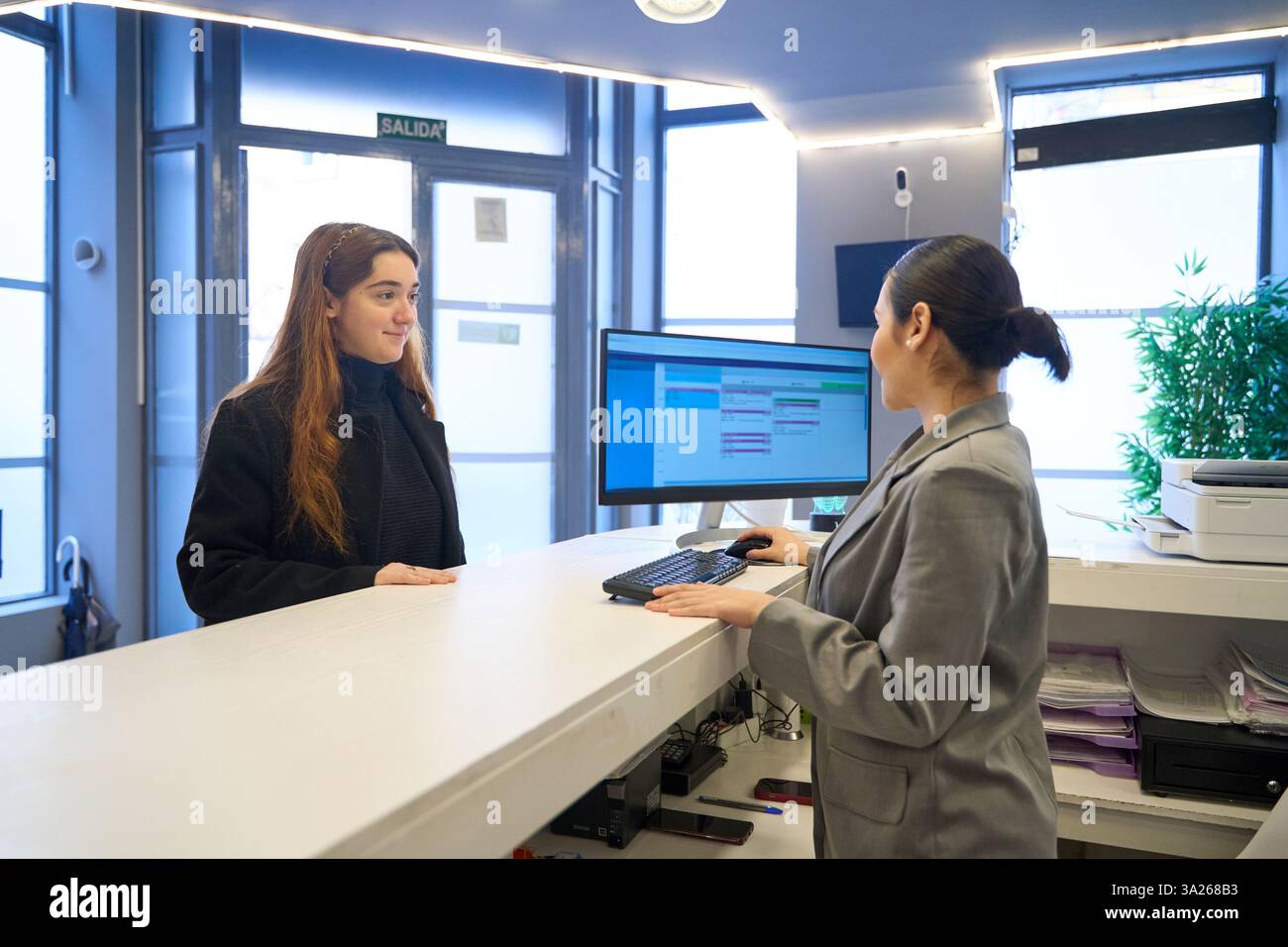 Dental clinic secretary managing patient appointments while working on ...