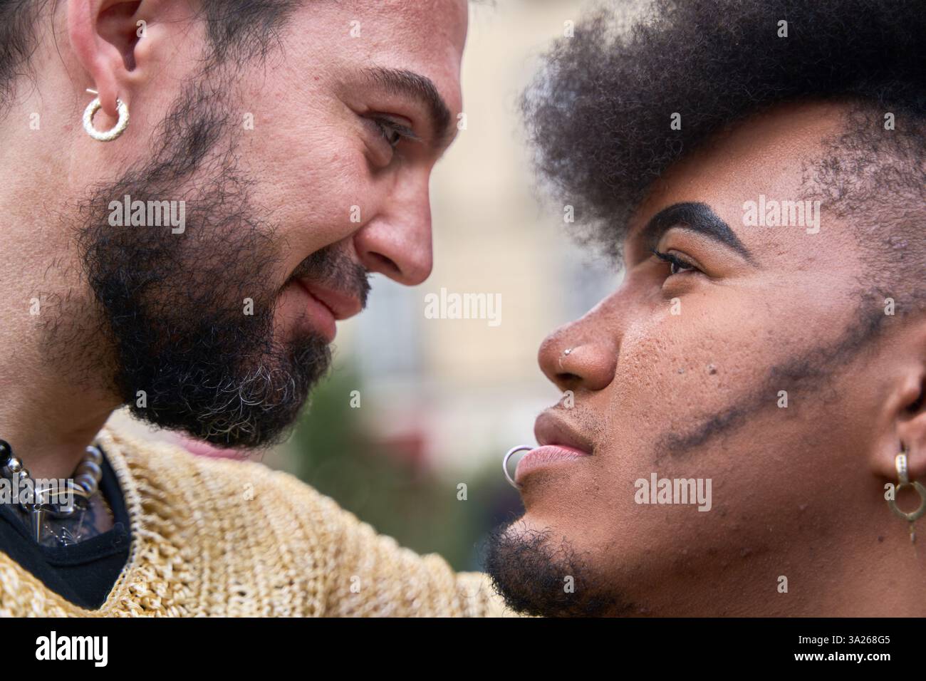 Two men are sharing a tender moment outdoors, gazing into each other's ...