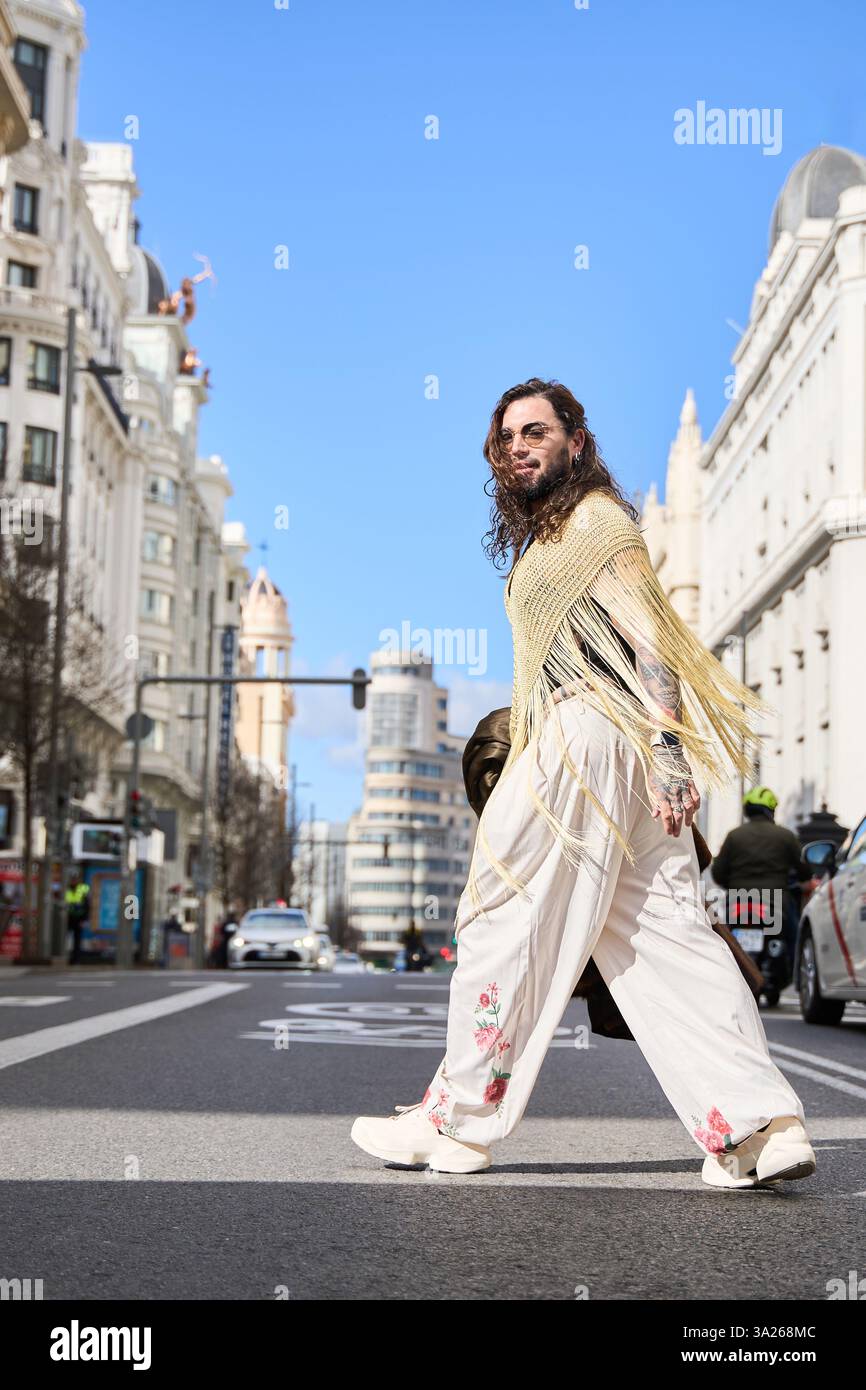 Stylish non binary person with long hair and beard walking on a city ...