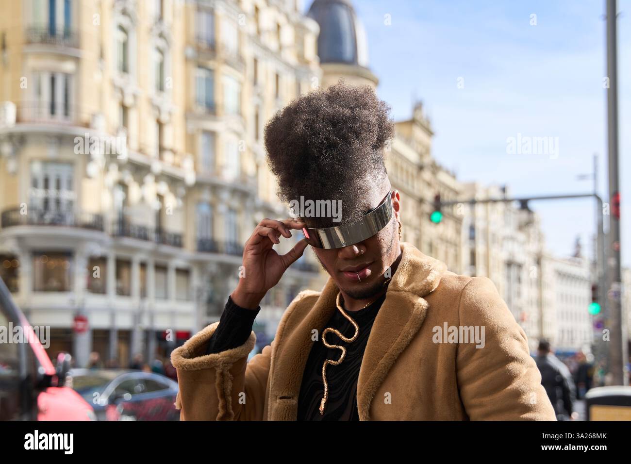 Fashionable androgynous person with afro hairstyle adjusting futuristic ...