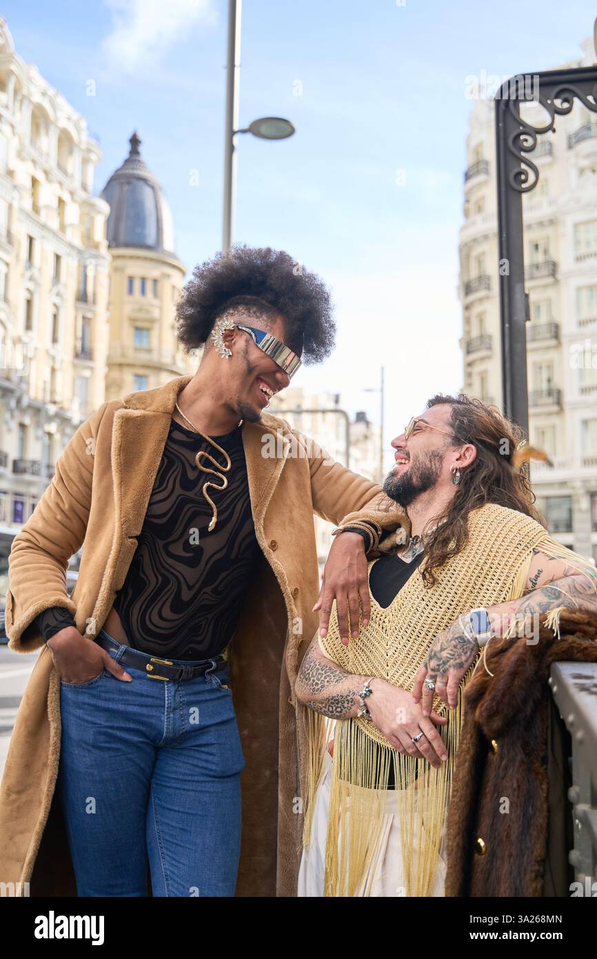 Two androgynous non binary people wearing modern clothes are enjoying a ...
